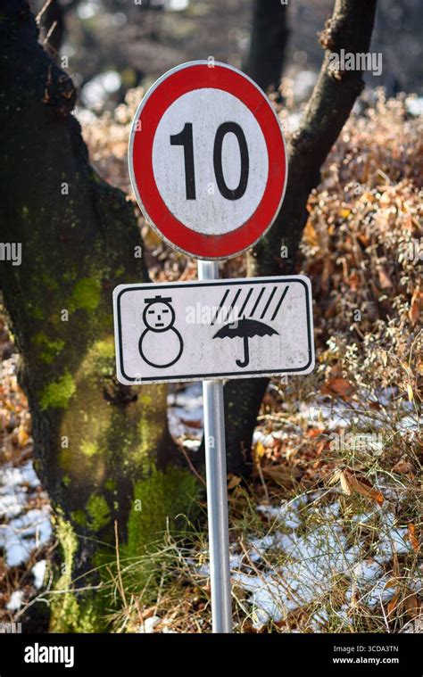 A Speed Limit Sign With A Snowman And Umbrella Symbol Cautioning Slower