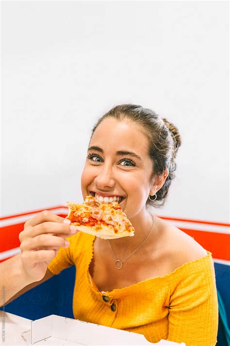 Happy Teen Girl Eating Pizza By Stocksy Contributor Victor Torres