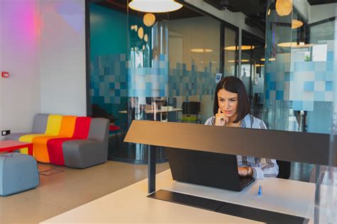 전염병 동안 현대 사무실에서 아크릴 유리 재채기 벽 가드 뒤에 일하는 젊은 비즈니스 여성 뒤에 대한 스톡 사진 및 기타 이미지 뒤 사람들 투명 아크릴 유리 Istock