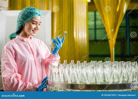 A Woman In Chemical Science A QC Worker In Uniform Examines Glass Bottles Stock Image Image Of