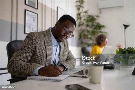 사무실에서 노트북으로 작업하면서 메모를 하는 흑인 사업가 25 29세에 대한 스톡 사진 및 기타 이미지 25 29세 2명 55 59세 Istock