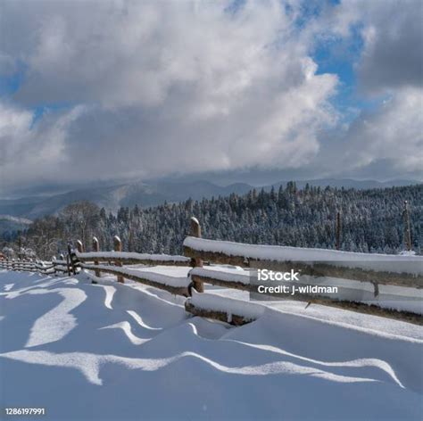 나무 울타리에서 눈 위에 그림자를 흔들었다 알프스 산 겨울 작은 마을 외곽 눈 덮인 경로 멀리 안개와 흐린 언덕에 전나무 숲 0명에 대한 스톡 사진 및 기타 이미지 Istock