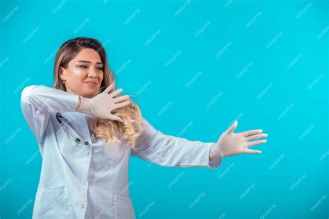 방향을 보여주는 흰색 제복을 입은 여성 의사 무료 사진