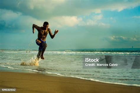 매력적인 젊은 운동과 강한 아프리카계 미국인 흑인 비치 훈련 열심히 하 고 역주에서 프로 선수 생활에서 바다 물에 실행 하 고