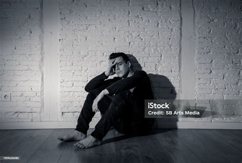 사람 슬픔 정서적 고통 외로움과 가슴 아픈 개념에서 우울증을 앓고 고통 받는 끔찍한 감정을 우는 슬픈 우울한 젊은이의 초상화와 복사 공간 및 어두운 분위기의 빛 감정에 대한