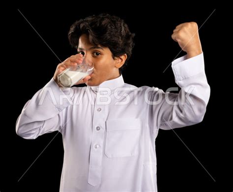 بورتريه لولد عربي خليجي سعودي يرتدي الثوب السعودي يقوم بشرب الحليب