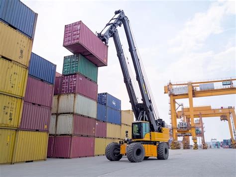 A Reach Stacker Lifting And Stacking Shipping Containers At A Container
