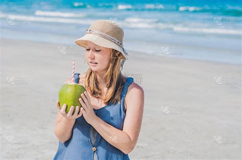 迷人的年轻女子在海滩上喝椰子汁 迷人的年轻女子在海滩上喝椰子汁