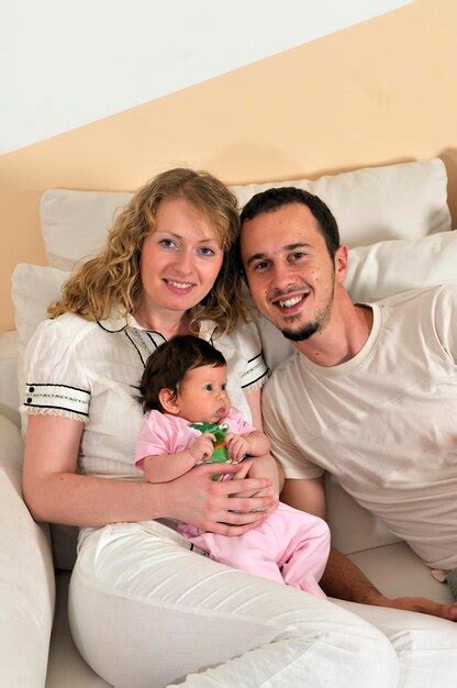Retrato interior con una familia joven feliz y un lindo bebé Foto Premium