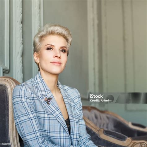 Perfect Blonde Short Haired Woman In Blue Suit Is Looking To The Camera