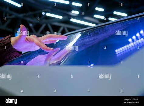 Woman Using Interactive Touchscreen Display At Technology Exhibition