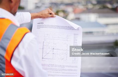 건설 현장 청사진 그리고 뒤에서 도시의 건축 제안서 문서를 읽는 남자 토목 공학의 산업 발전을 위한 평면도 프로젝트 또는 건축의