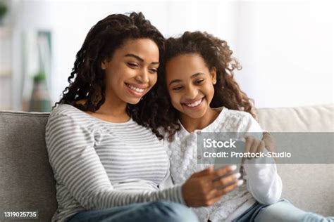 스마트 폰을 함께 사용하는 쾌활한 아프리카 계 미국인 어머니와 딸 2명에 대한 스톡 사진 및 기타 이미지 2명 가족 곱슬 머리 Istock