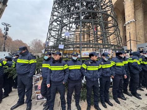 ახლადდამონტაჟებული ნაძვის ხის გარშემო პოლიციელები დადგნენ