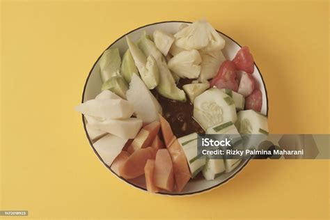 Rujak Buah는 신선한 열대 과일로 구성된 인도네시아 디저트입니다 그것은 야자 설탕 타마 린드 칠리 마늘 및 소금으로 만든