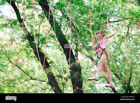 Adventure Climbing High Wire Park Hiking In The Rope Park Girl In Safety Equipment Stock Photo