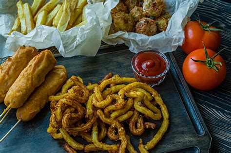 감자와 치즈의 나선형 오일 튀긴 감자 튀김 개 옥수수 야채 양배추 크로켓과 소스감자 배경에 신선한 야채와 채소로 장식 케첩