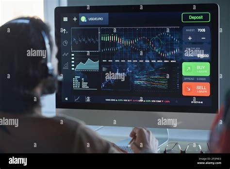 Rear View Of Programmer Looking At Computer Monitor And Working Over Software With Diagrams At