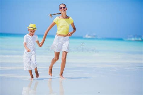 Brother And Sister Runing On The Beach During The Hot Summer Vacation