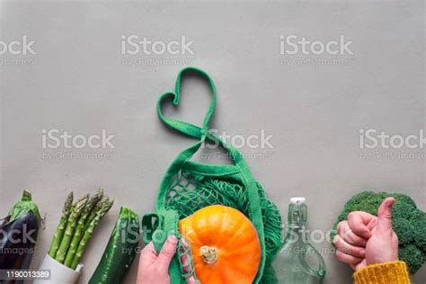 환경 친화적 인 제로 폐기물 플랫 오렌지 호박 브로콜리와 문자열 가방을 들고 손으로 누워 공예 종이 배경 텍스트 공간에 야채와 손으로 평평한 평신도가 됩니다 가지 채소에