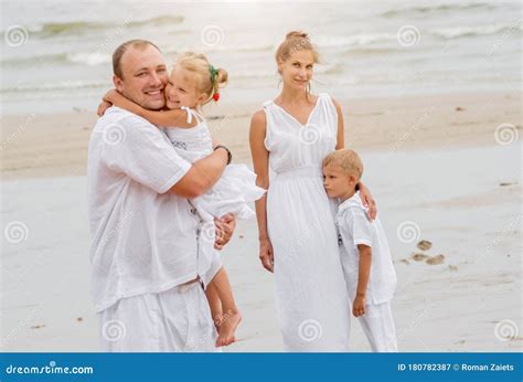 Feliz Familia Joven Al Atardecer En La Playa Imagen De Archivo Imagen De Cabrito Amor 180782387
