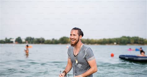 Young Wet Man Having Fun At Summer Festival Standing In Lake Copy