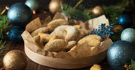 수제 크리스마스 견과류 쿠키 바닐라 초승달 크리스마스 장식에 설탕 가루 새해와 크리스마스 축하 개념입니다 공간을 복사합니다 소프트 포커스 플라잉 슈가 파우더 사진