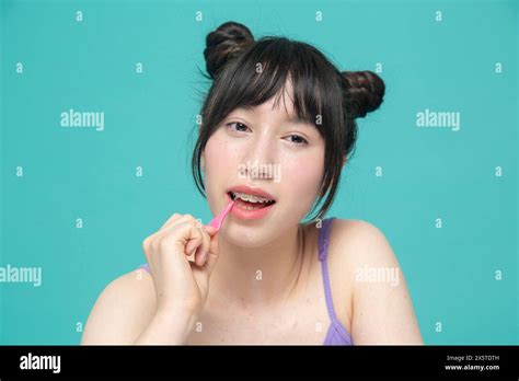 Studio Portrait Of Girl Brushing Braces With Interdental Brush Stock