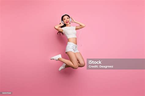 그녀의 전체 길이 몸 크기보기 그녀의 좋은 매력적인 사랑스러운 사랑스러운 쾌활한 쾌활한 쾌활한 물결 모양의 머리 소녀 점프 재미 를 듣고 히트 곡 팝 영혼 핑크 파스텔 색상