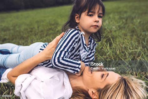 녹색 잔디 야외에 그녀의 귀여운 어린 소녀와 놀고 아름 다운 여자의 측면 보기 사랑 행복 예쁜 엄마와 딸 공원에서 시간 함께 지출 엄마와 아이가 재미가 있다 행복 한 어머니