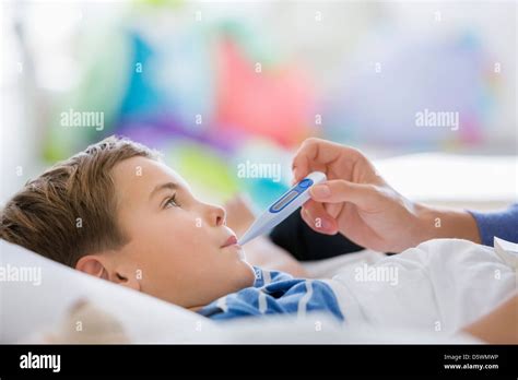 Mother Taking Son S Temperature Stock Photo Alamy