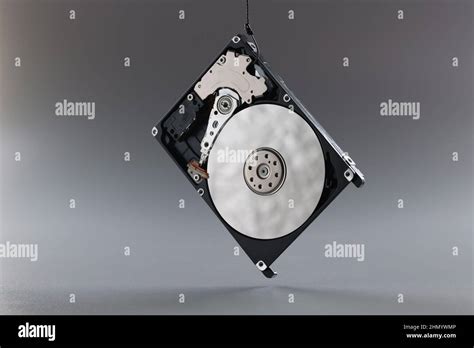 Computer Hard Disk Drive On Hook Black Hardware Disk Memory Storage Cylinder On Grey
