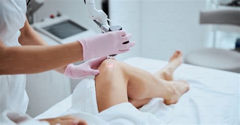 레이저 치료 중 소파에 누워 목욕 가운을 입은 환자의 자른 사진 사진 Unsplash의 다리 이미지