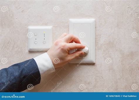 Man Regulating Temperature On Air Conditioning Controller Thermostat On