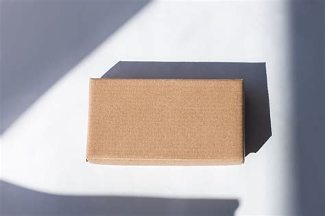 창조적 인 미니멀리즘 스타일의 흰색 배경에 자연 햇빛 그림자와 크래프트 골판지 포스트 소포 에코 기프트 박스 0명에 대한 스톡 사진 및 기타 이미지 Istock