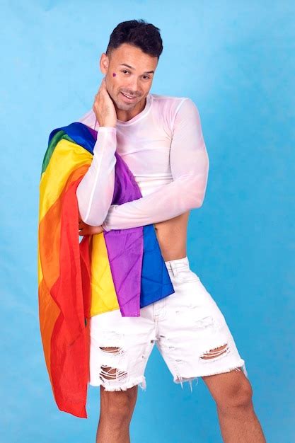 Chico Gay Sonriendo Con La Bandera Del Orgullo Sobre Su Hombro Fondo Azul Foto Premium
