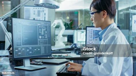 정교한 코딩 및 그의 데스크톱 컴퓨터에 프로그래밍 하 고 그의 책상에 앉아 되는 아시아 과학자 배경 컴퓨터 과학 연구 실험실에서 로봇 팔 모델 중국에 대한 스톡 사진 및