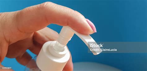 파란색 배경에 스프레이 건으로 스프레이 병을 들고있는 소녀의 손에 손 피부 관리 및 질병의 의료 예방은 손을 씻는 것을 의미합니다 Fragrance Foundation에
