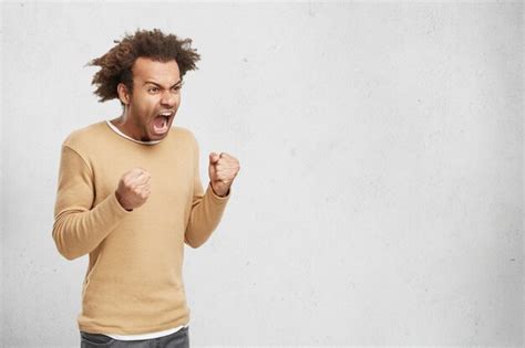 Free Photo Furious Outaged Man Shouts In Anger Keeps Fists Going To