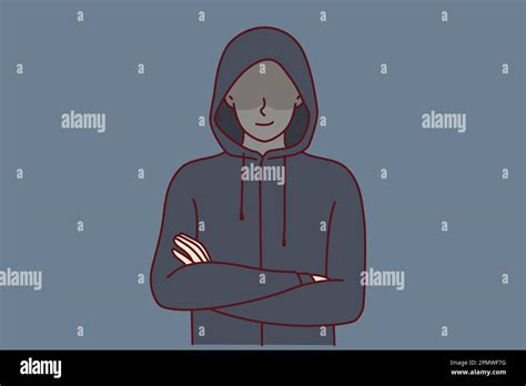 anonymous man stands with arms crossed and hiding eyes behind hood for