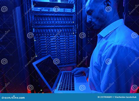 System Administrator Troubleshooting Server Rack With Laptop Stock