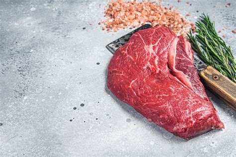 생 프라임 소고기 스테이크 탑 등심 또는 분홍색 소금과 로즈마리를 곁들인 럼프가 있는 정육점 보드 회색 배경 맨 위 보기입니다 복사 공간 0명에 대한 스톡 사진 및 기타