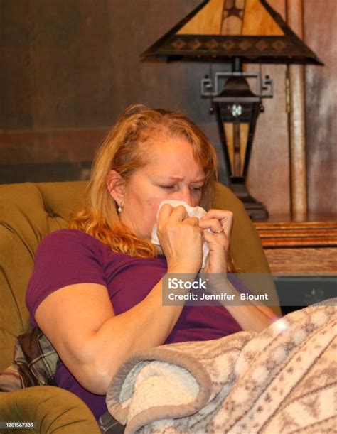 중년 백인 여성은 조직으로 코를 불고 감기 호흡기 감염 또는 독감으로 비참해 보입니다 A형 인플루엔자 바이러스에 대한 스톡 사진