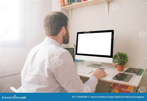Young Man Looking At Computer Monitor During Working Day In Home Office Stock Image Image Of