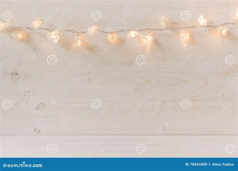 Света рождества горя на белой деревянной предпосылке Стоковое Изображение изображение