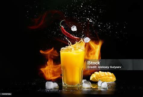 카모마일 소스와 칠리 라임 향신료를 곁들인 Mangonada 멕시코 망고 스무디 검은 배경에 망고와 칠리 후추 칵테일 얼음