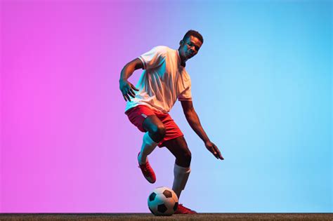 한 아프리카 남자 프로 축구 선수 훈련 네온 빛에 그라데이션 블루 핑크 배경에 고립 25 29세에 대한 스톡 사진 및 기타