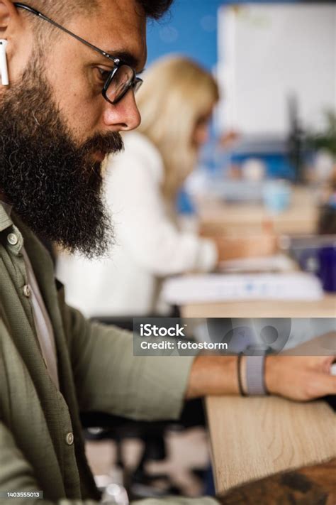 Portrait Of Hipster Programmer Coding At His Desk Listening To Music