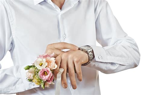 그 사람은 중요 한 모임을 준비 하 고 있다 결혼식 날의 시작 신랑은 셔츠를 입고 시계를 본다 흰색 배경에 고립 된 꽃의 무리와 손을 닫습니다 경영자에 대한 스톡 사진 및