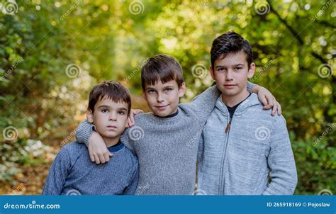 Portrait Of Three Boys Brothers Standing In Forest Stock Image